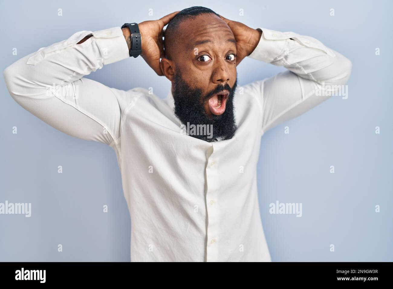 African american man standing over blue background crazy and scared ...
