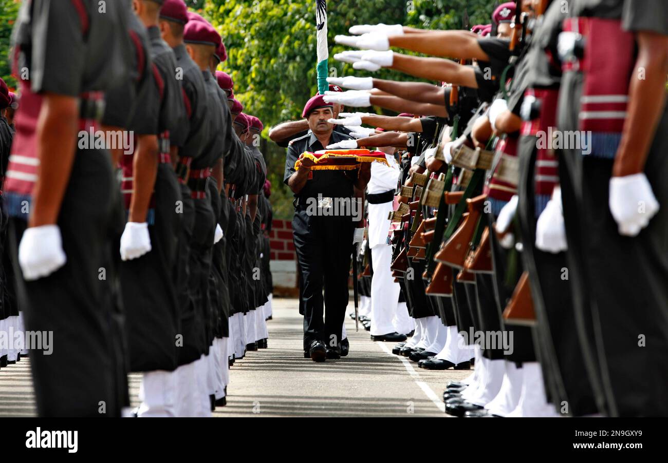 An Indian army official, carrying religious books on a tray, walks past ...