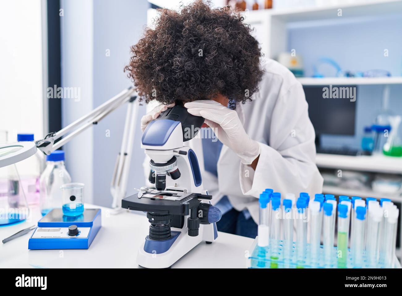 African american woman scientist using microscope at laboratory Stock Photo - Alamy