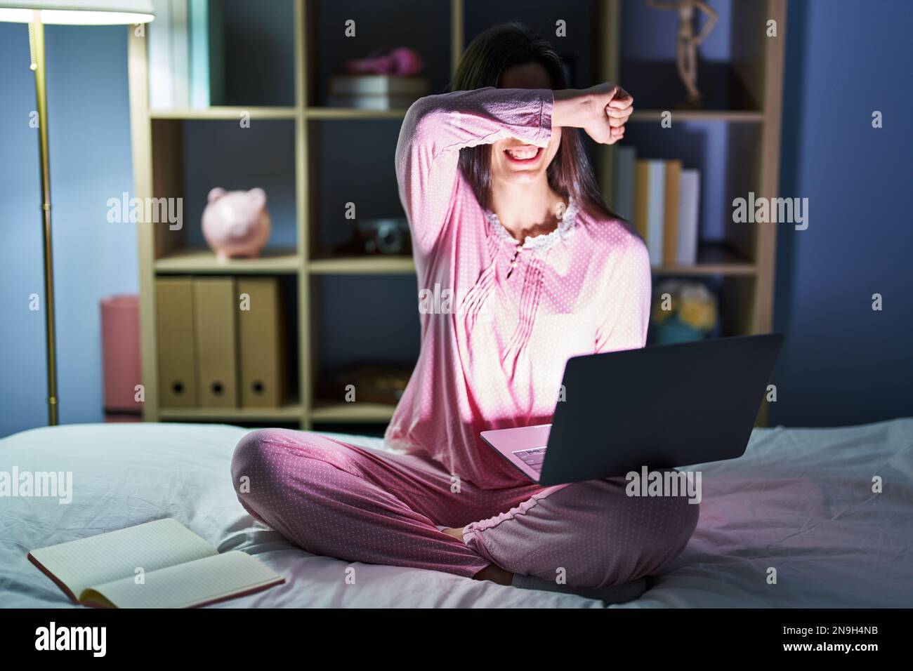 Young hispanic woman using computer laptop on the bed smiling cheerful ...