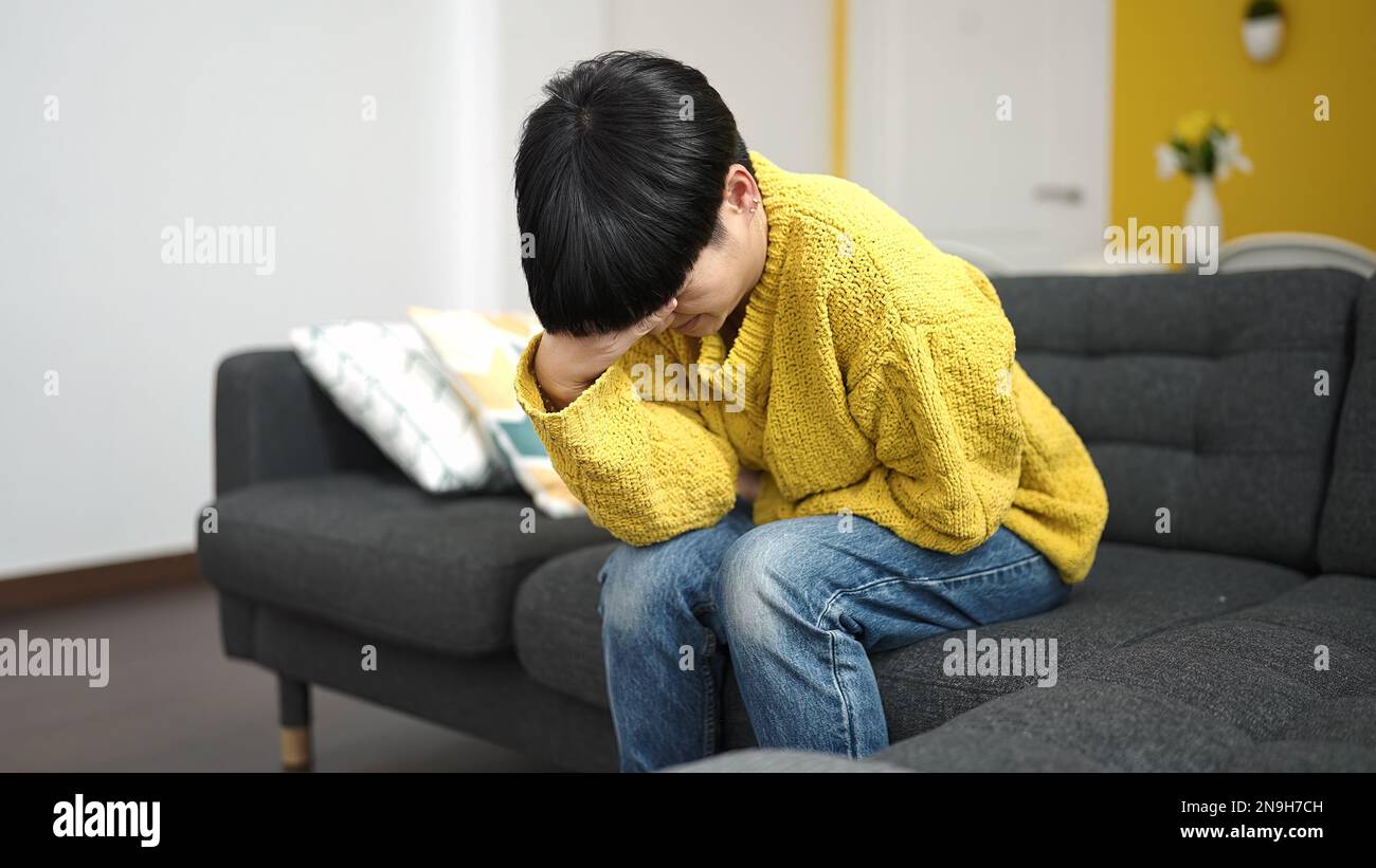 Young chinese woman suffering for head and stomach ache at home Stock ...
