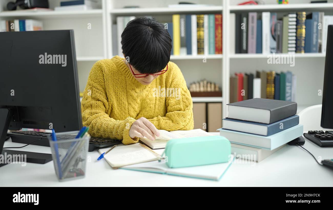 Young chinese woman student reading book studying at library university ...