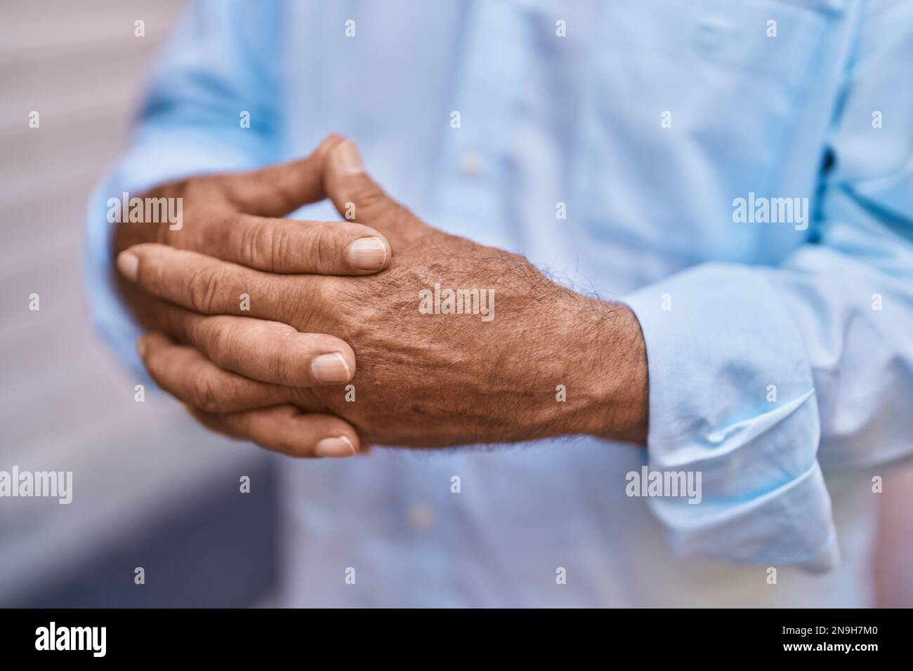 Senior grey-haired man with hands together at street Stock Photo - Alamy