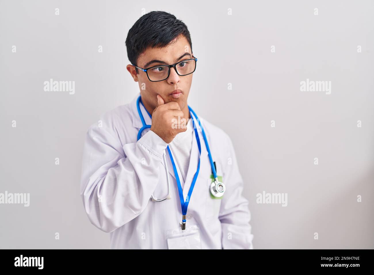 Young hispanic man with down syndrome wearing doctor uniform and ...