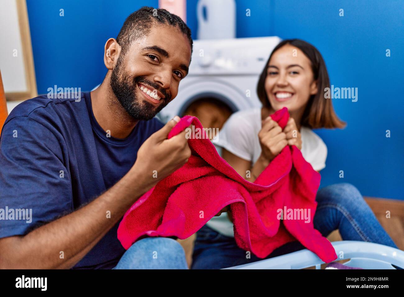 Man and woman couple smelling towel washing clothes at laundry Stock Photo - Alamy