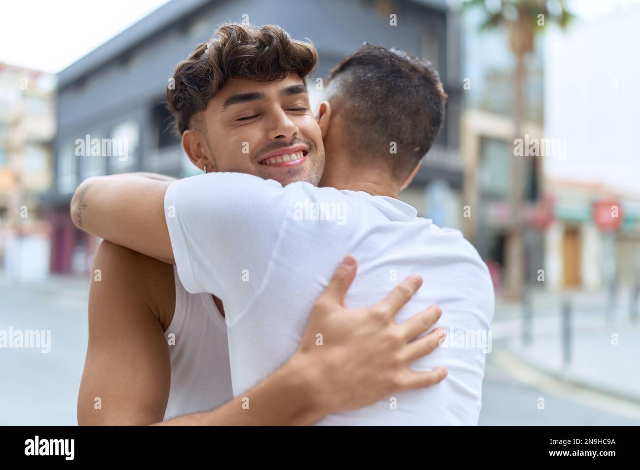Two hispanic men couple smiling confident hugging each other at street ...