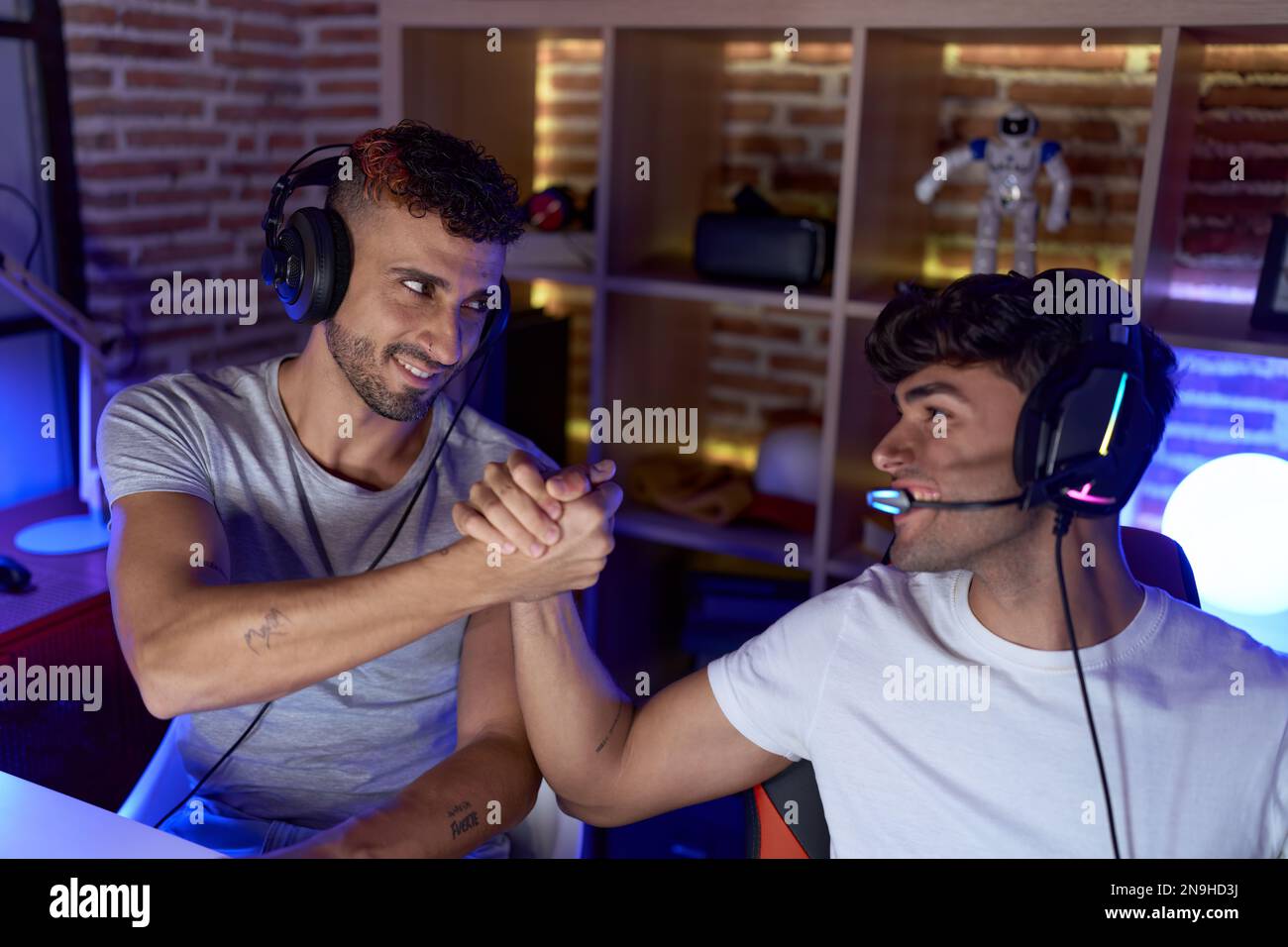 Two hispanic men streamers playing video game shake hands at gaming ...