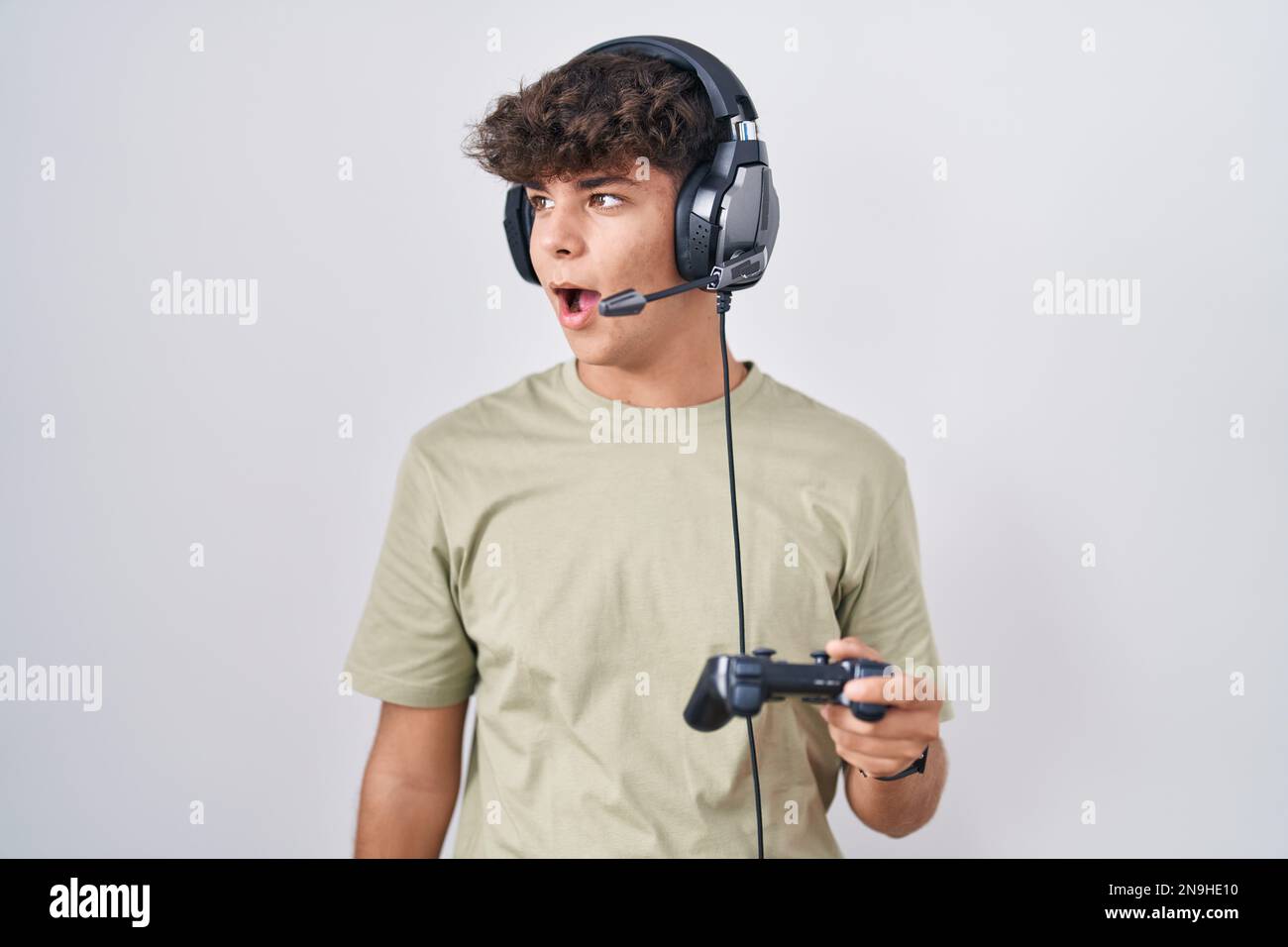 Hispanic teenager playing video game holding controller angry and mad ...
