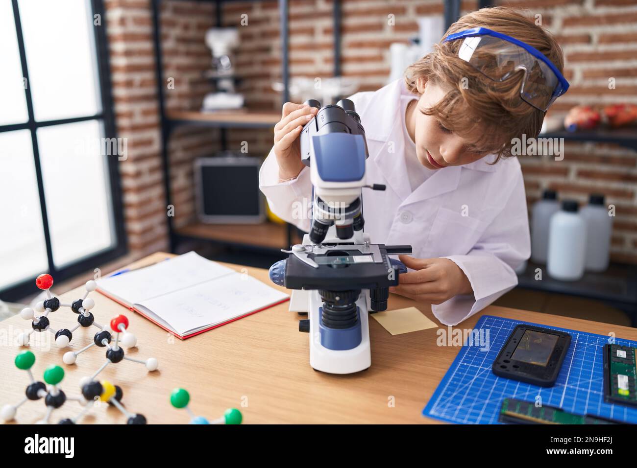 Adorable caucasian boy student using microscope at classroom Stock ...