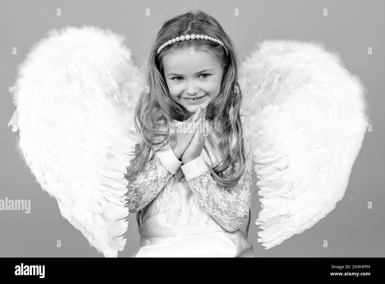 Beautiful little angel girl standing with your arms close to your chest ...