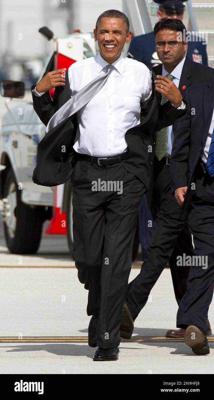 President Barack Obama takes off his jacket as he steps off of Air ...