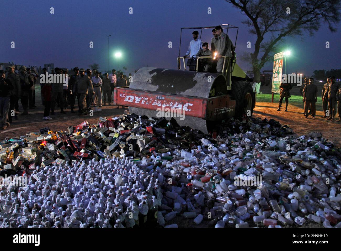 Pakistani security officers crush bottles of alcohol, during a ceremony ...