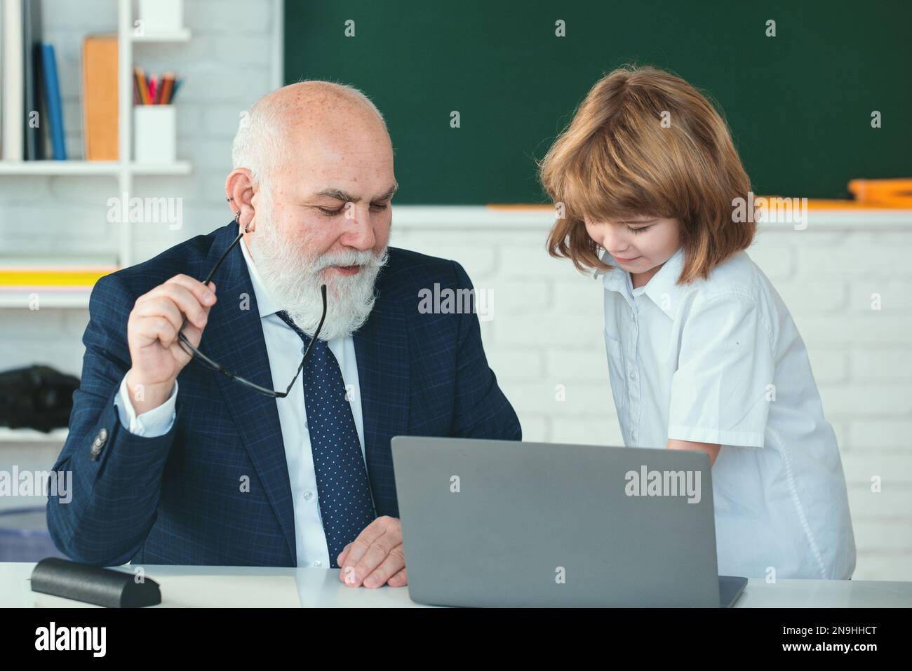 Pupil learning. Boy elementary school. Old and Young. Professor and ...