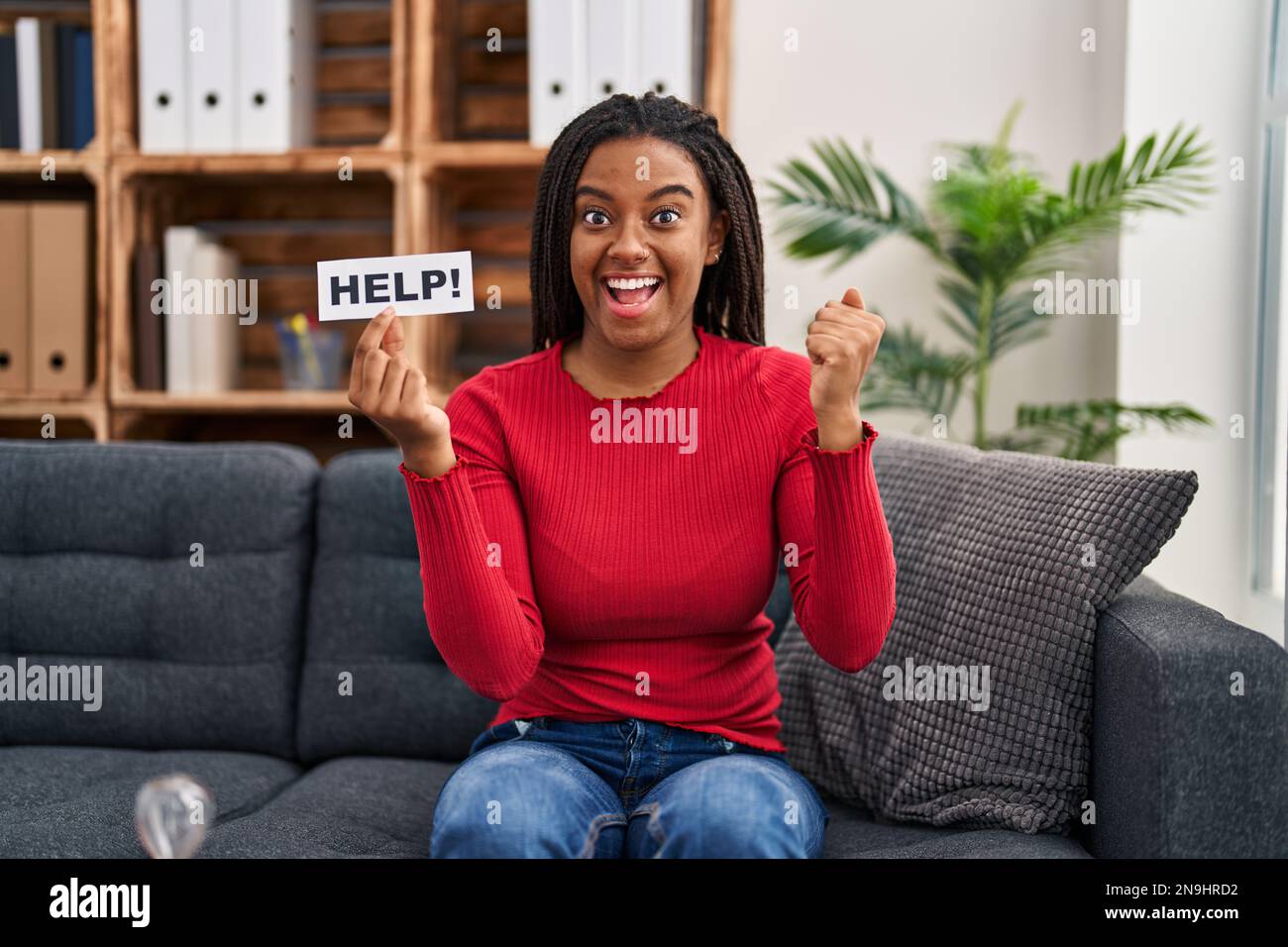 Young african american with braids doing therapy holding help banner ...