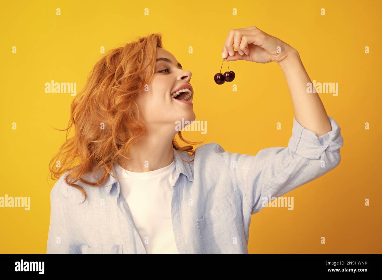 Attractive young woman eating fresh cherry. Healthy summer fruits ...
