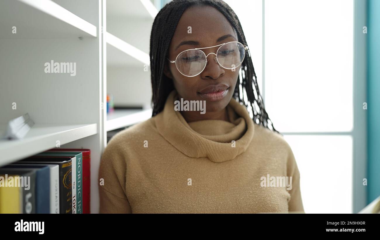 African woman reading a book at library university Stock Photo - Alamy