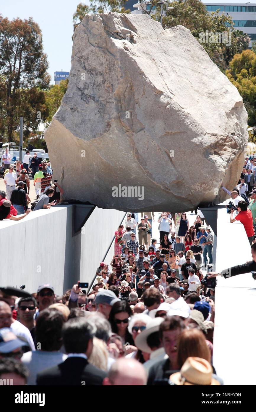 During a dedication ceremony visitors view Michael Heizer’s "Levitated ...