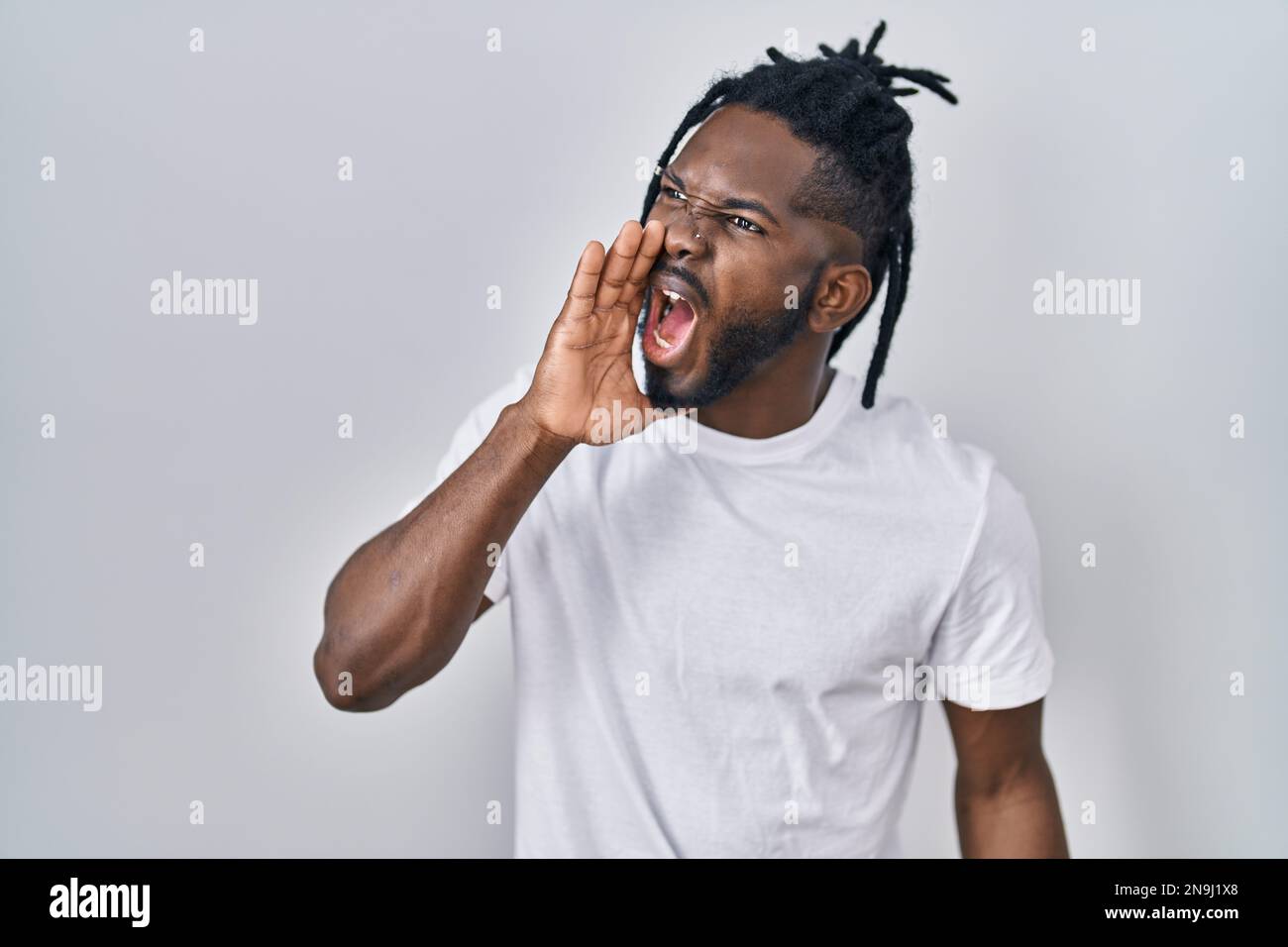 African man with dreadlocks wearing casual t shirt over white ...