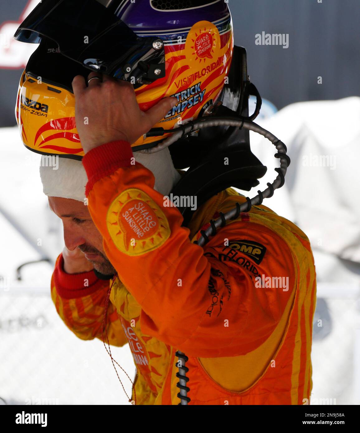 Driver Patrick Dempsey puts on his helmet for the start of the Rolex ...