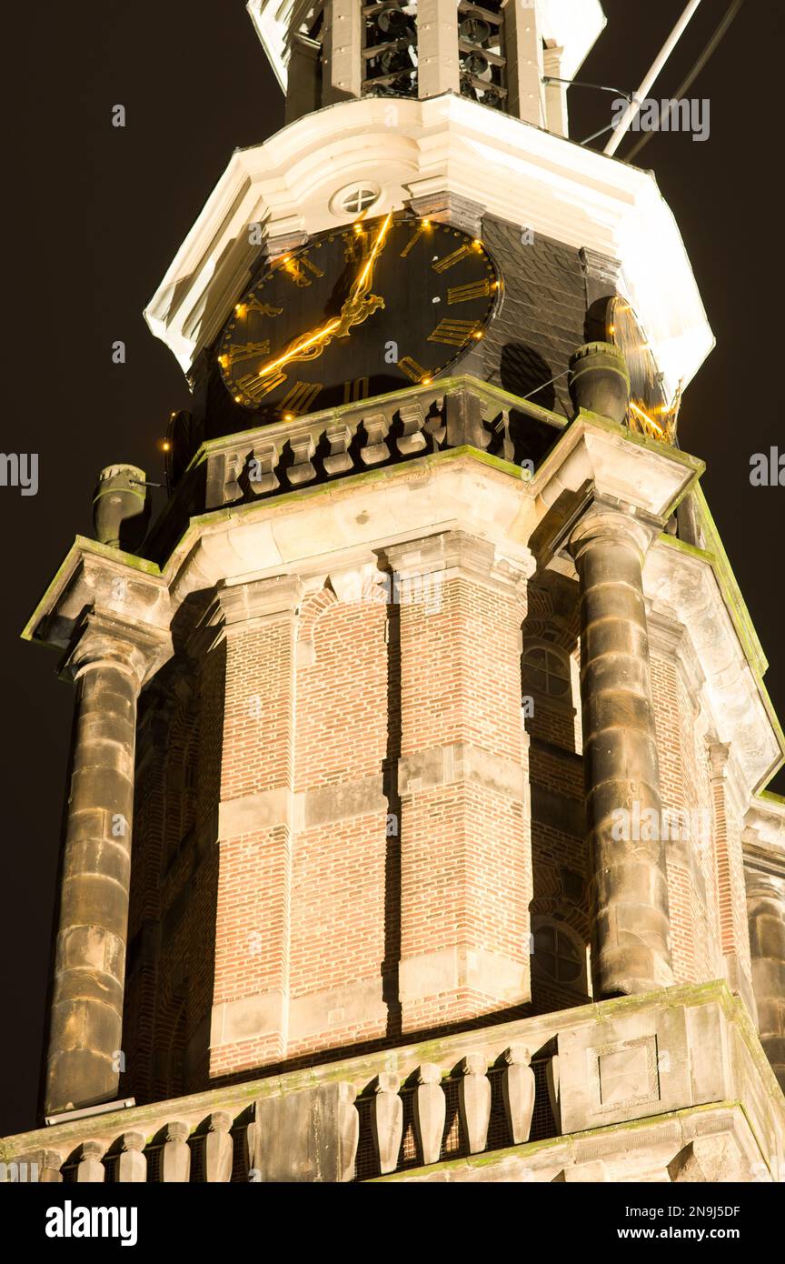 Closeup of a illuminated spire of a tower with clock in Zutphen in the ...