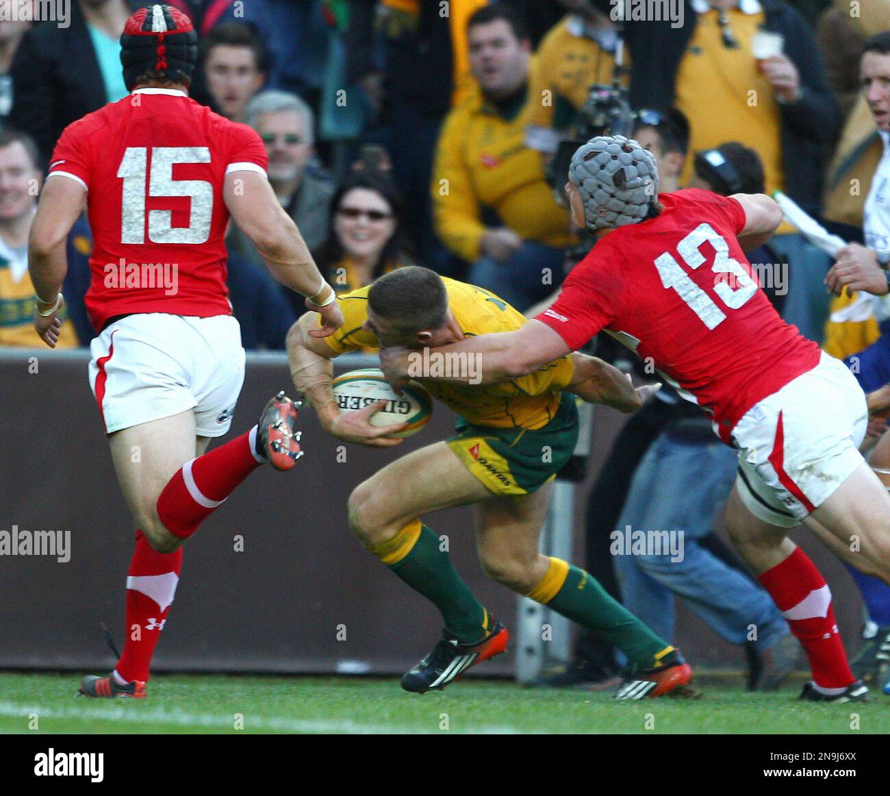 Australia's Rob Horne, center, drives through to score a try despite ...