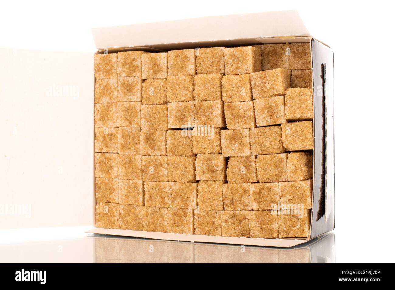 One paper box with brown sugar cubes, macro, isolated on white ...