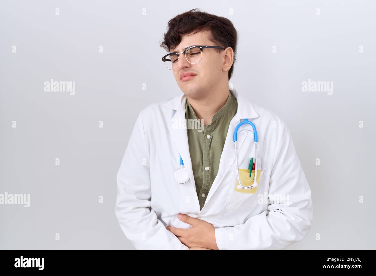 Young non binary man wearing doctor uniform and stethoscope with hand ...