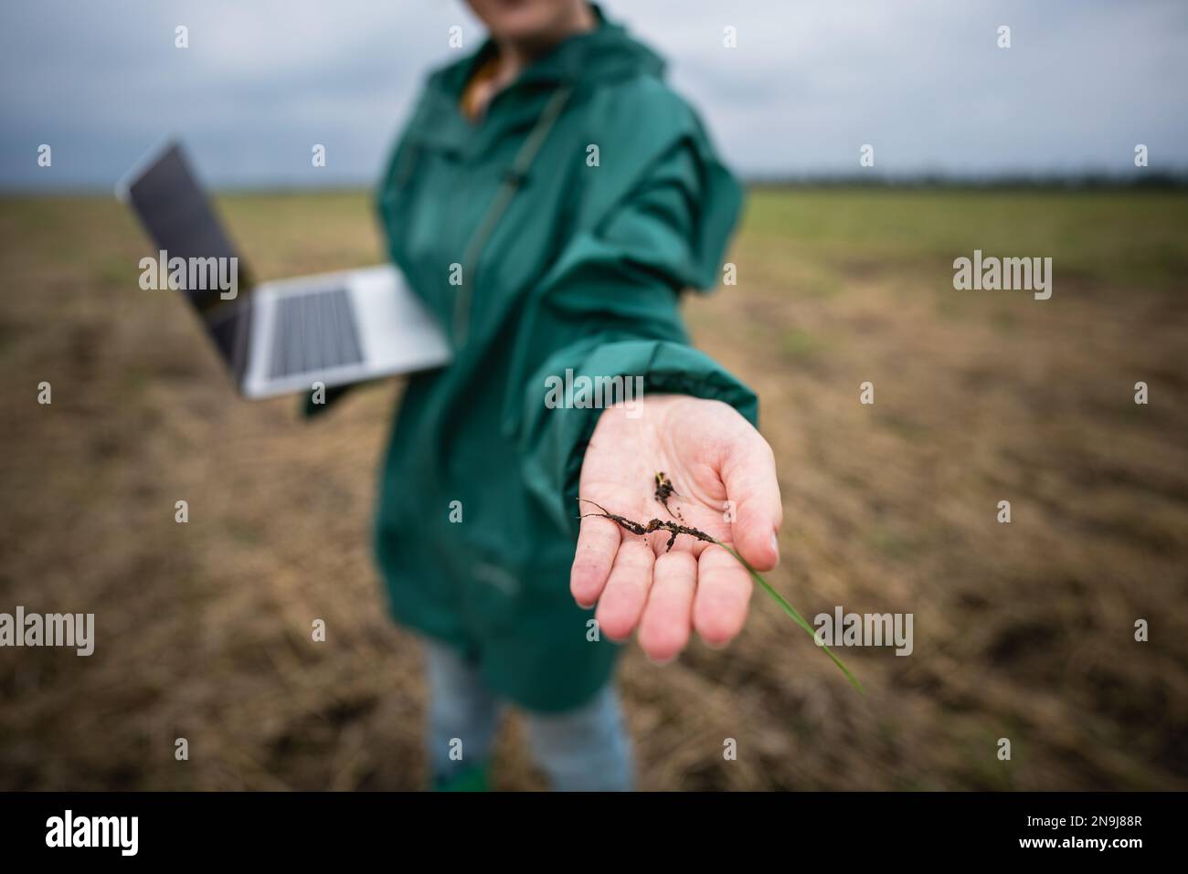 Farmer with laptop on the field. Smart farming and agriculture ...