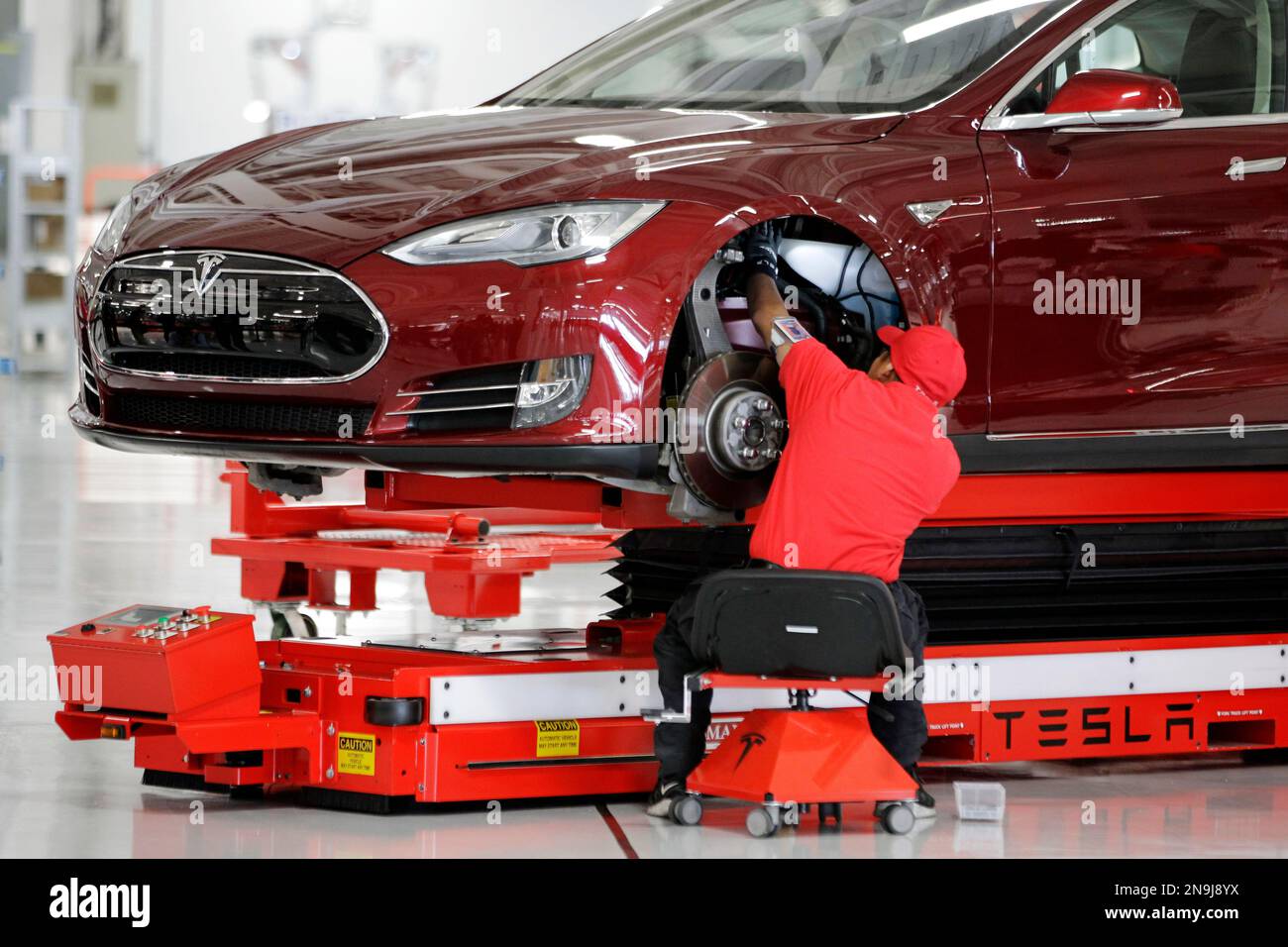 A worker assembles a Tesla Model S at the Tesla factory in Fremont ...
