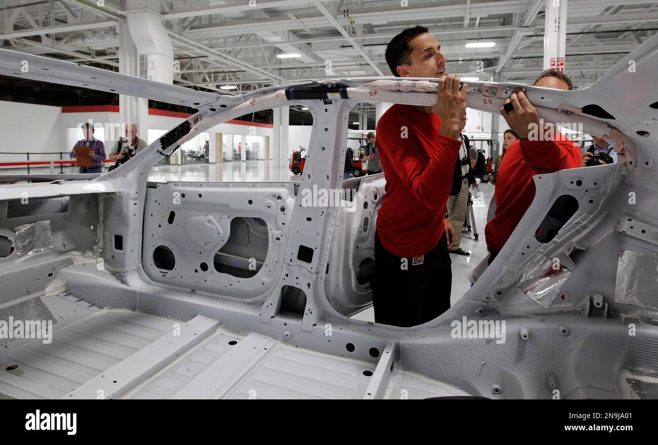 A worker inspects a Tesla Model S car at the Tesla factory in Fremont ...