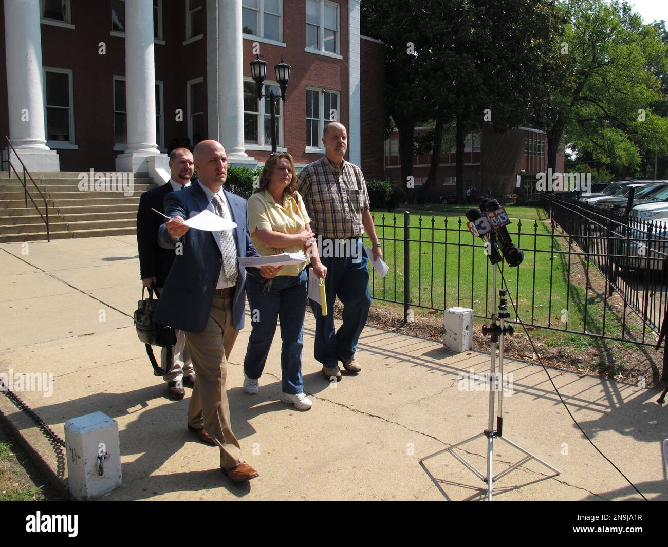 Ken Swindle, left, lawyer for Pam Hicks, center, prepares to hand out ...