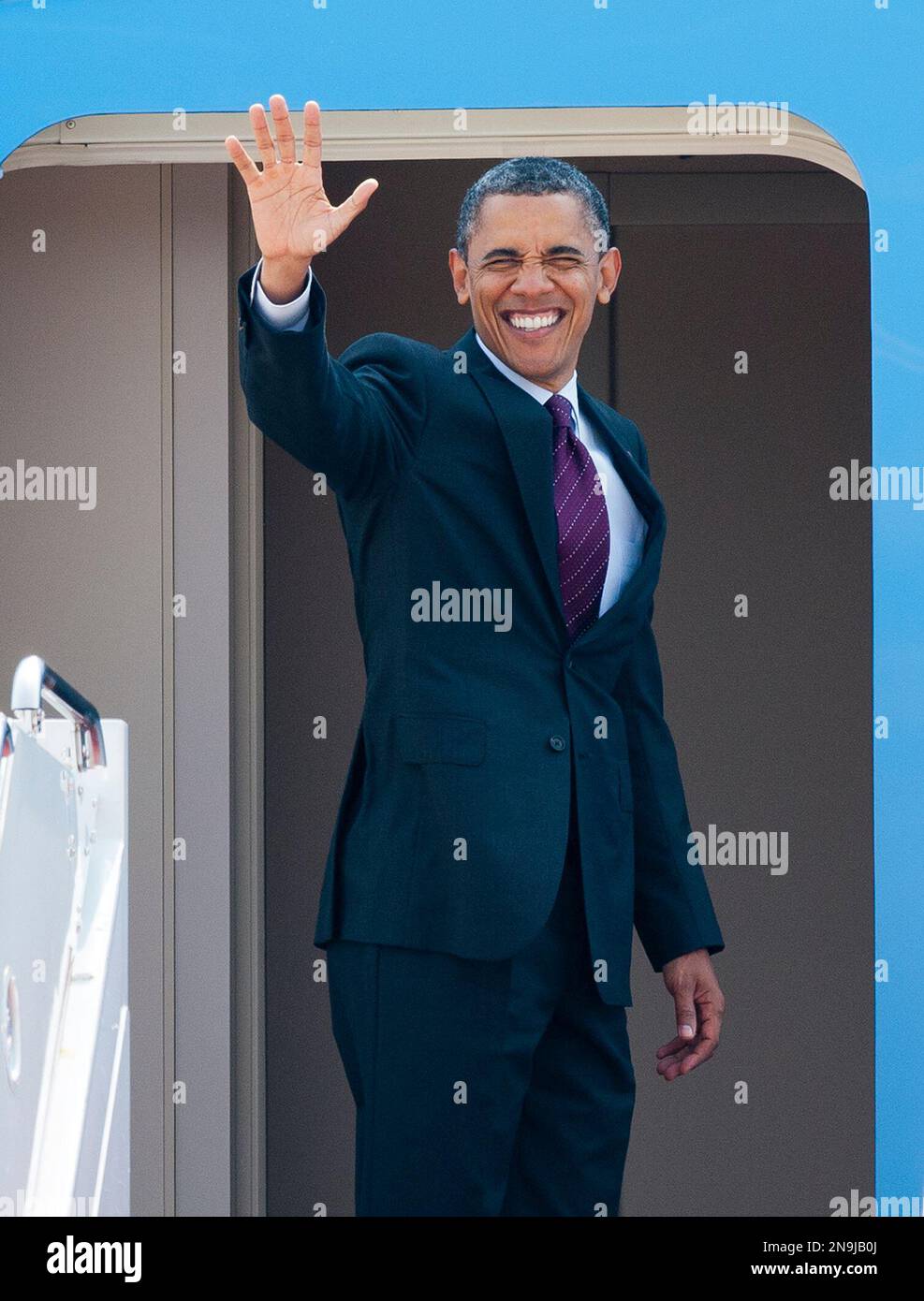 President Barack Obama wave as he boards Air Force One at Andrews Air ...