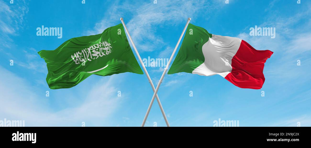 two crossed flags Italy and Saudi Arabia waving in wind at cloudy sky ...