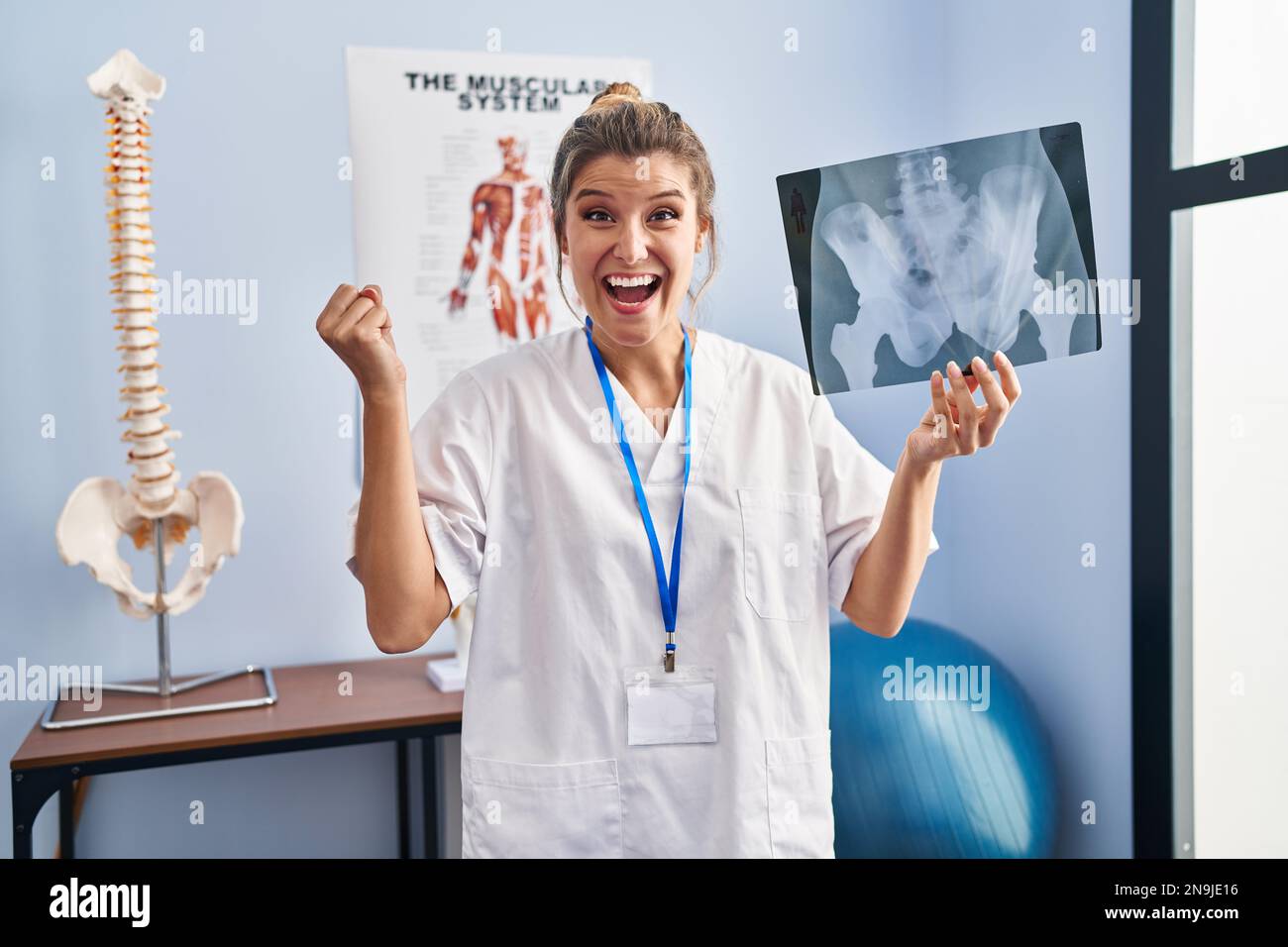 Young woman holding pelvis radiography celebrating victory with happy ...