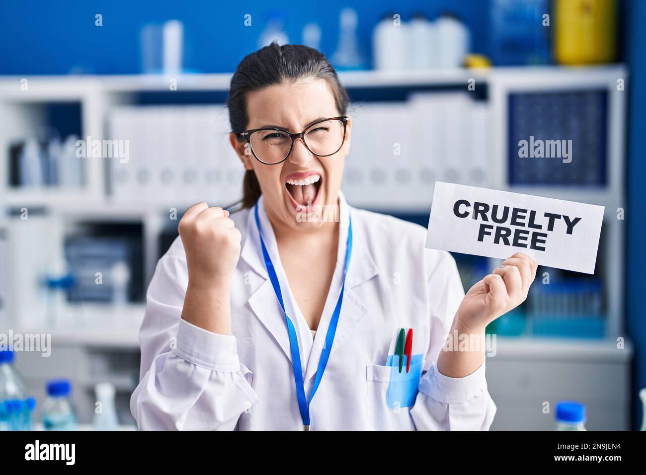 Young brunette woman working on cruelty free laboratory screaming proud ...