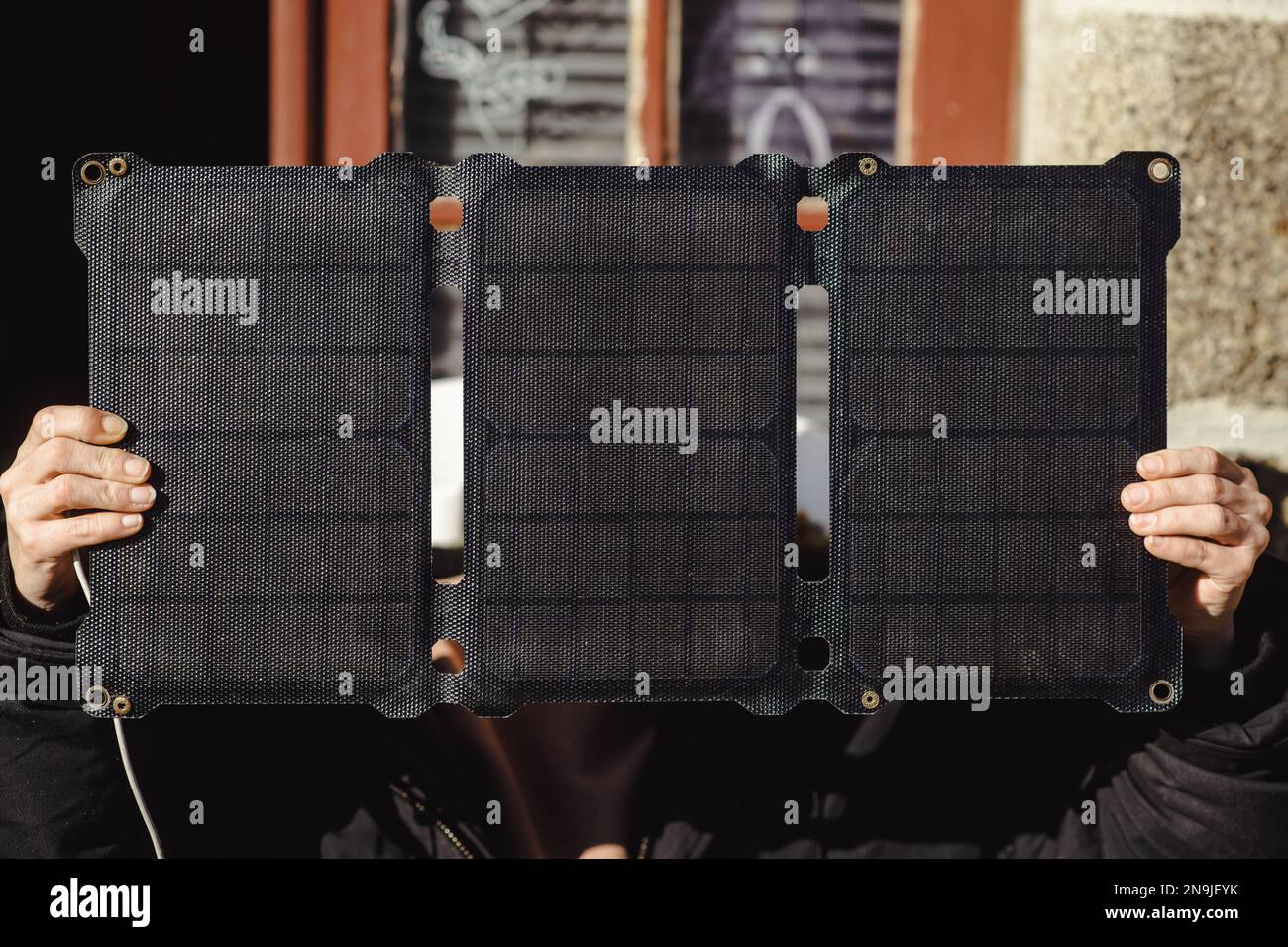 Portable solar battery in the hands of a woman. Alternative energy ...