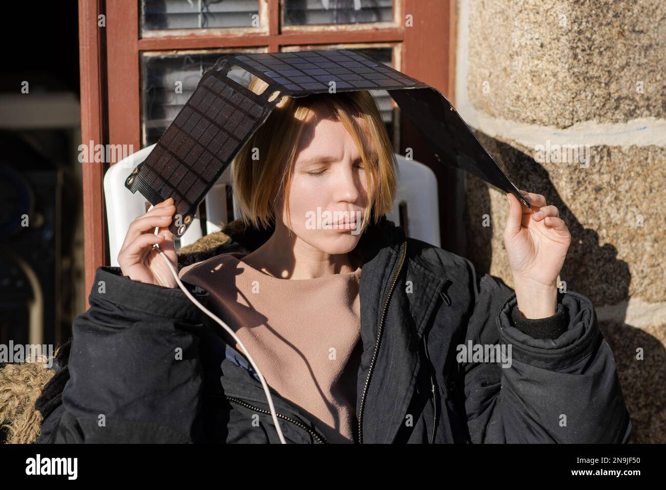 Portable solar battery in the hands of a woman. Charging mobile gadgets ...