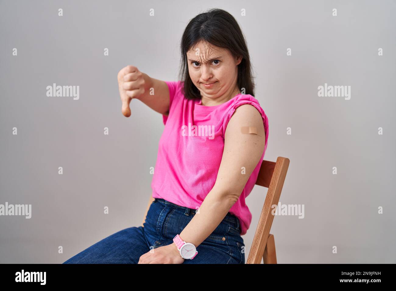 Woman with down syndrome wearing band aid for vaccine injection with ...