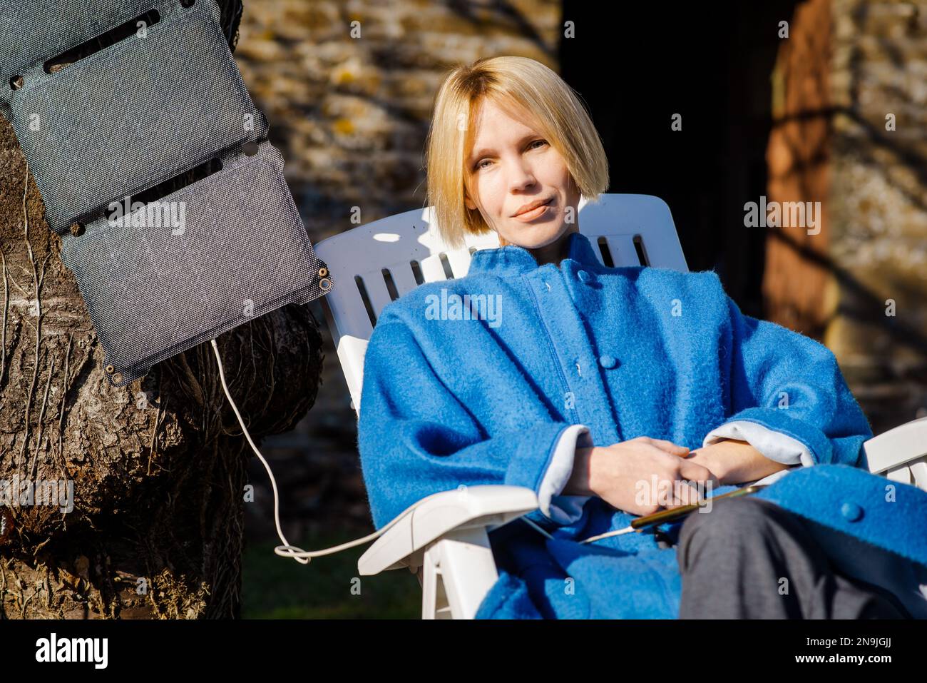 A portable solar battery and a resting middle-aged woman in her forties ...
