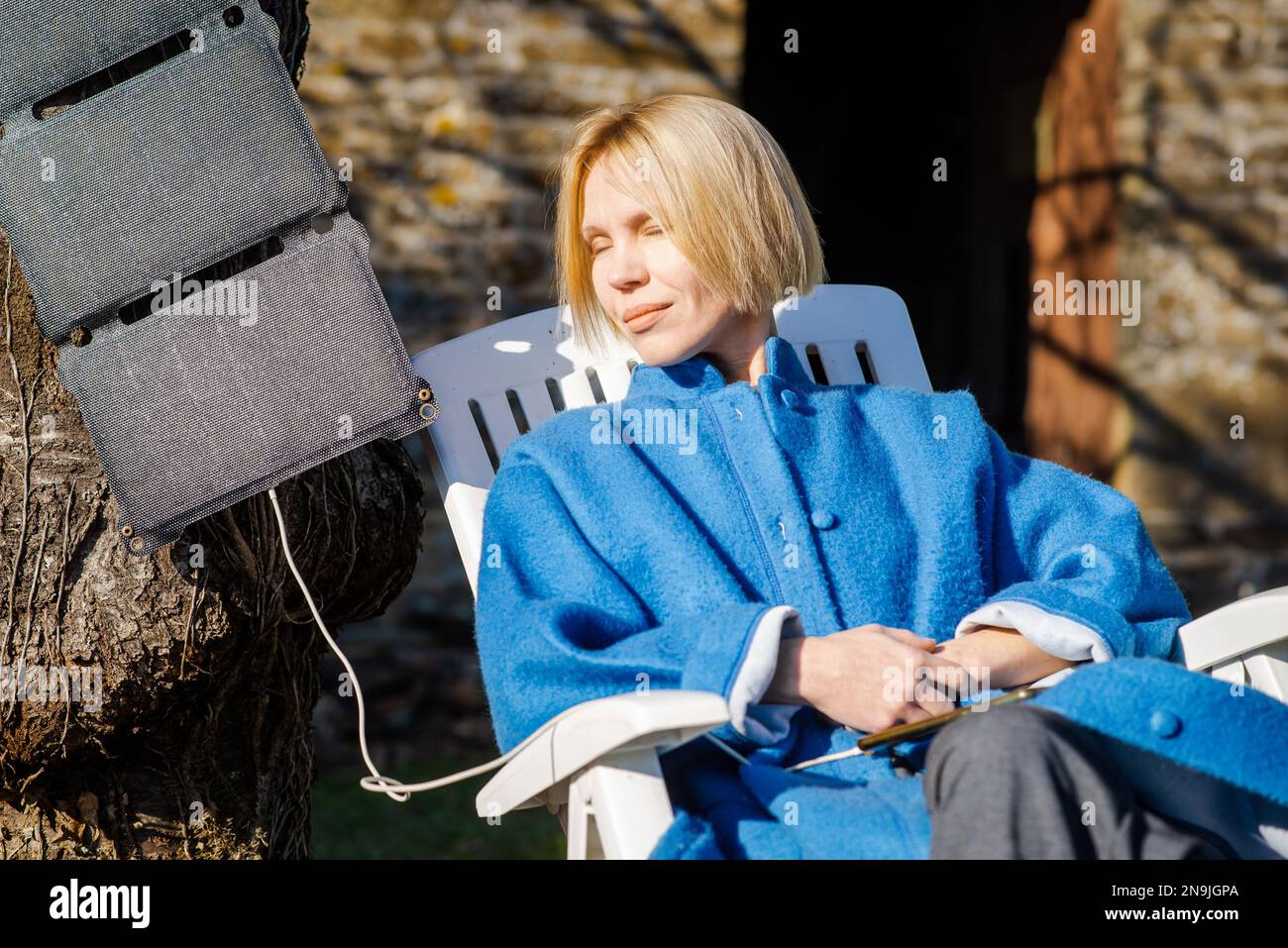 A portable solar battery and a resting middle-aged woman in her forties ...