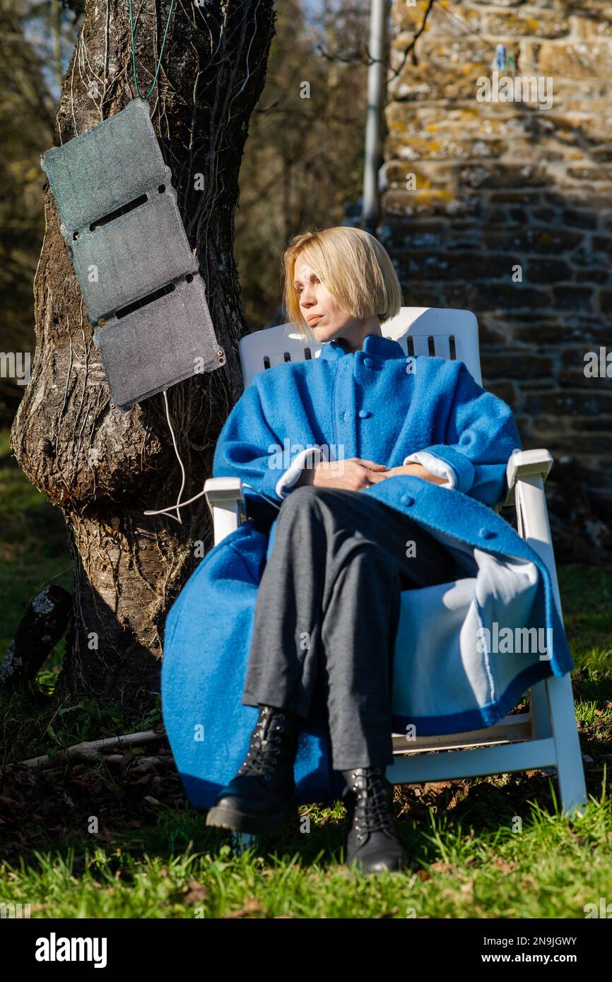 A portable solar battery and a resting middle-aged woman in her forties ...