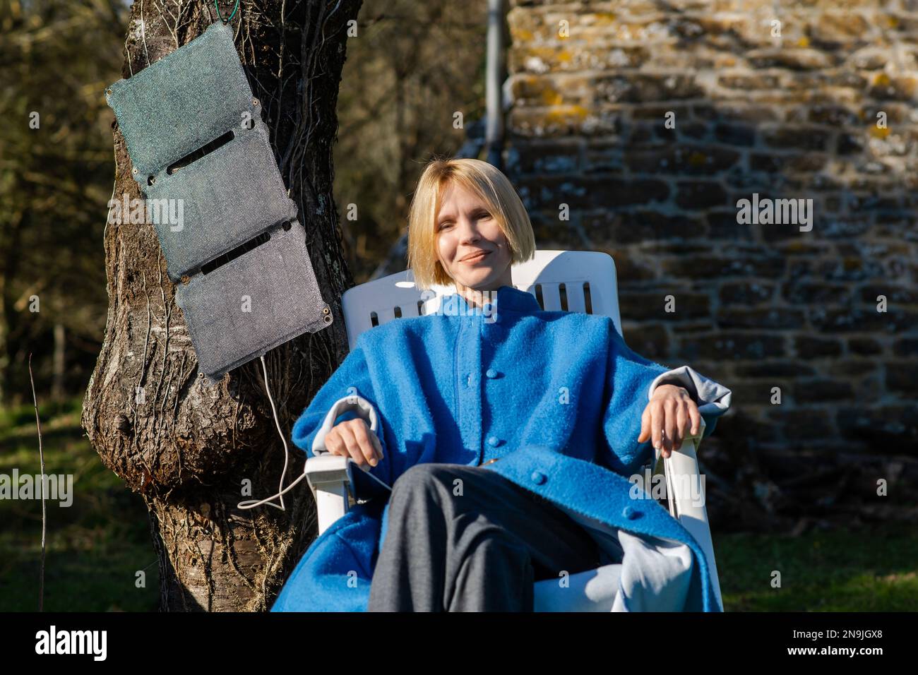 A portable solar battery and a resting middle-aged woman in her forties ...