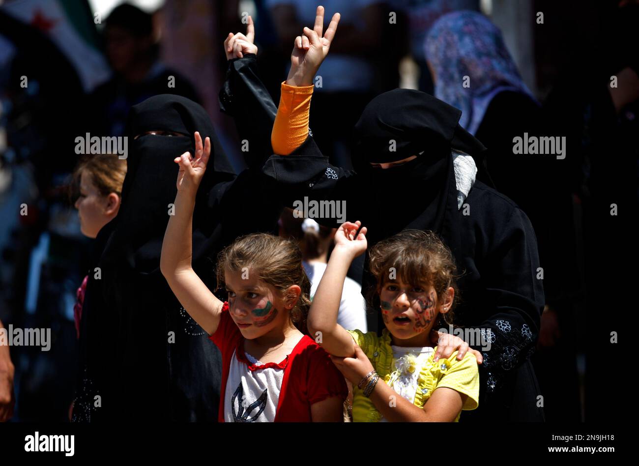 In this Friday, June 8, 2012 photo, Syrians flash the victory sign as ...