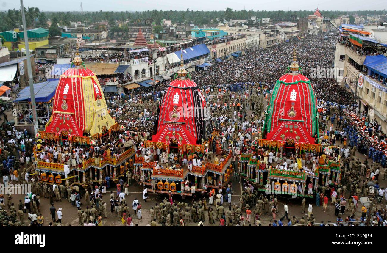 Devotees throng around the chariots as they wait to pull them during ...