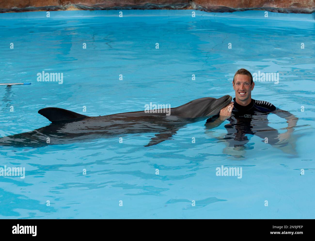 French swimmer champion Alain Bernard , swims with a dolphin at the ...