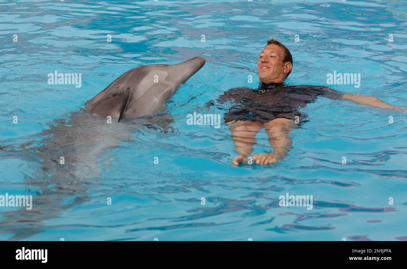 French swimmer champion Alain Bernard , swims with a dolphin at the ...