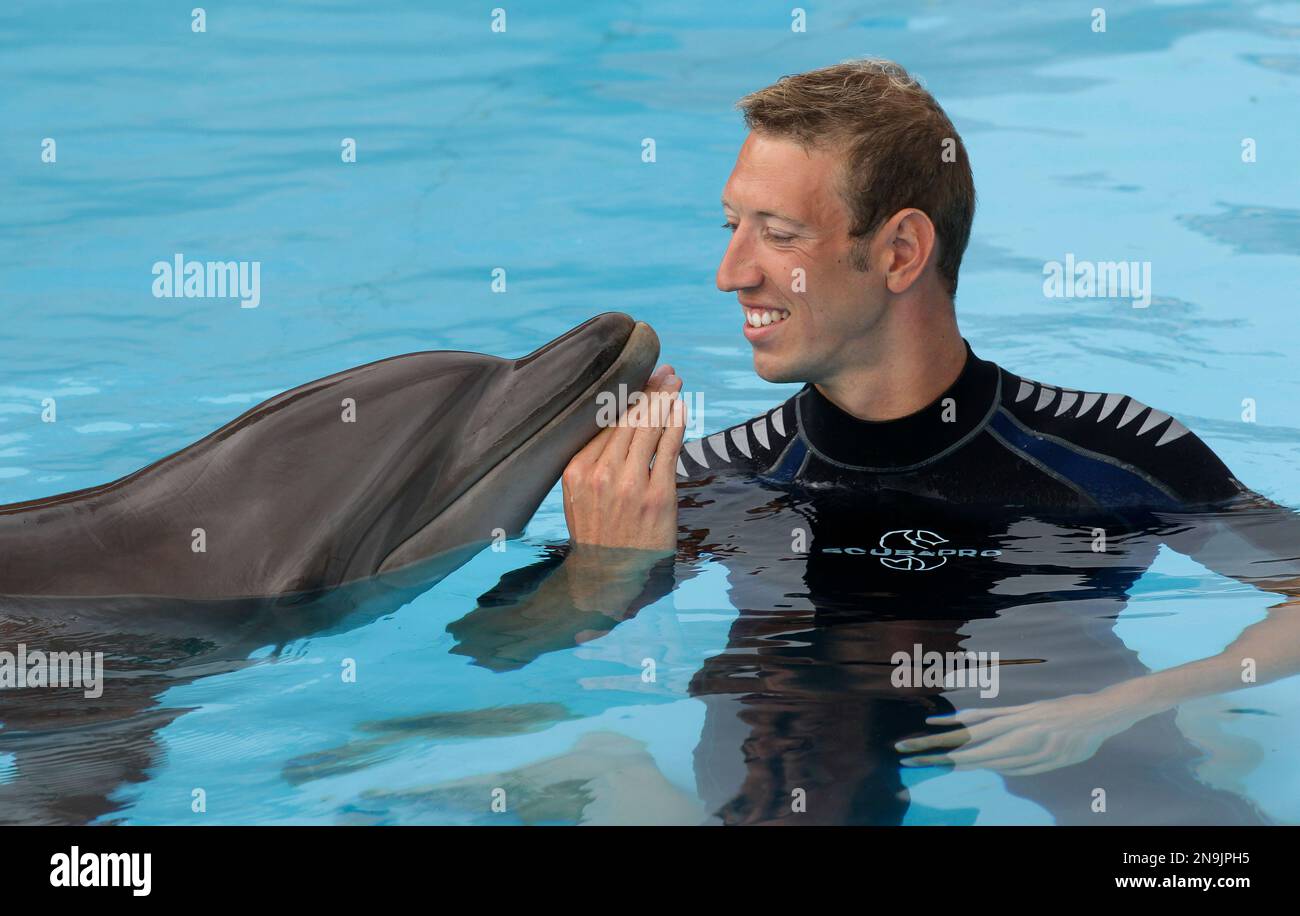 French swimmer champion Alain Bernard , swims with a dolphin at the ...
