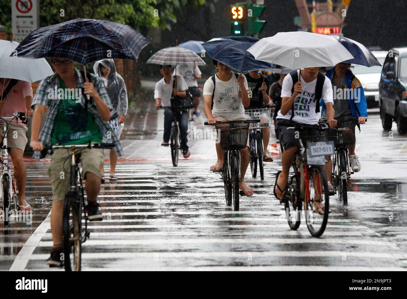 Students cross an intersection in the rain as tropical storm Talim ...