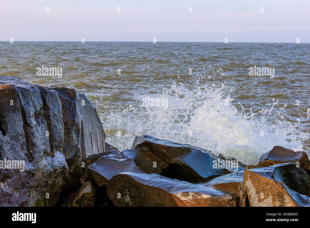 Wind blown waves hit the boulders along the wintery shoreline of Lake ...