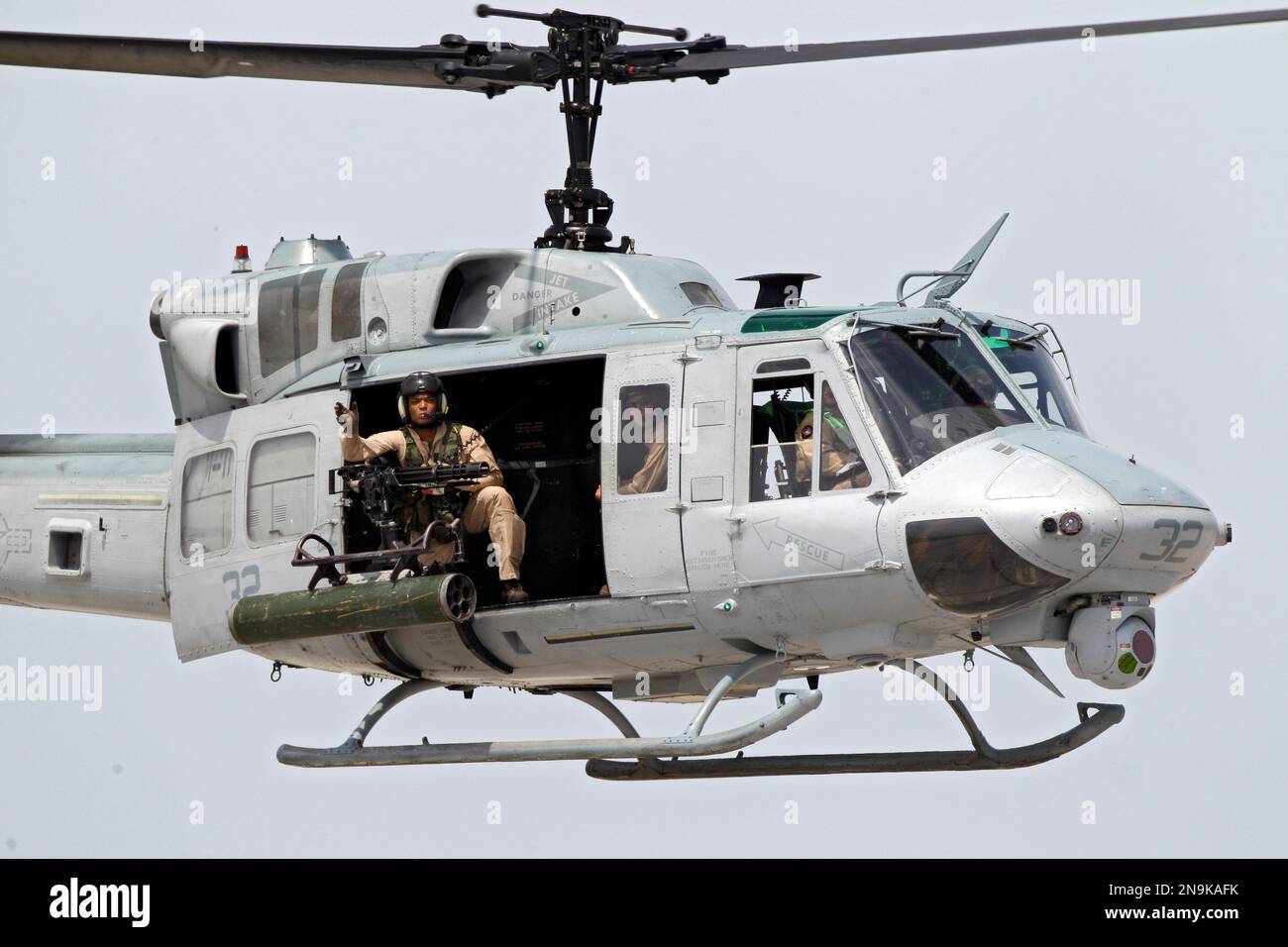 The door gunner in a Marine UH-1 Huey waves to the crowd following a ...